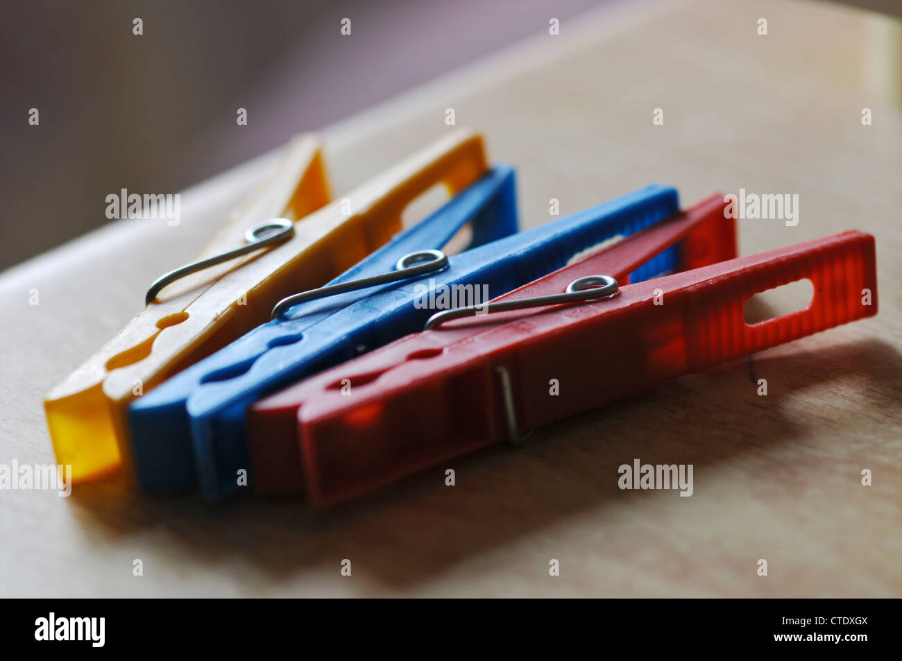 Three colourful pegs. One yellow, one blue and one red Stock Photo - Alamy