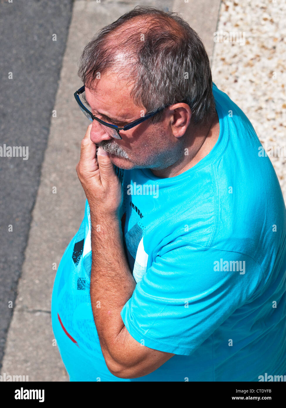 Obese balding man (from above) speaking on portable telephone - France ...