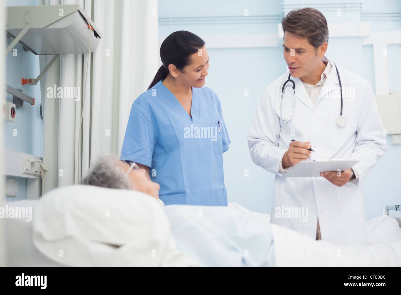 Doctor and nurse talking to a patient Stock Photo - Alamy