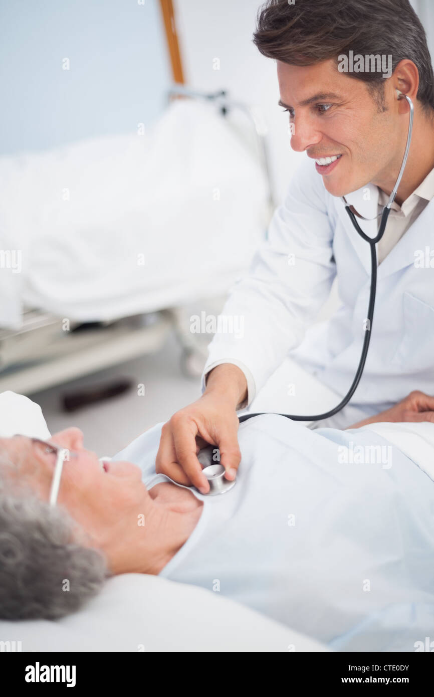 Doctor smiling while auscultating a patient Stock Photo - Alamy