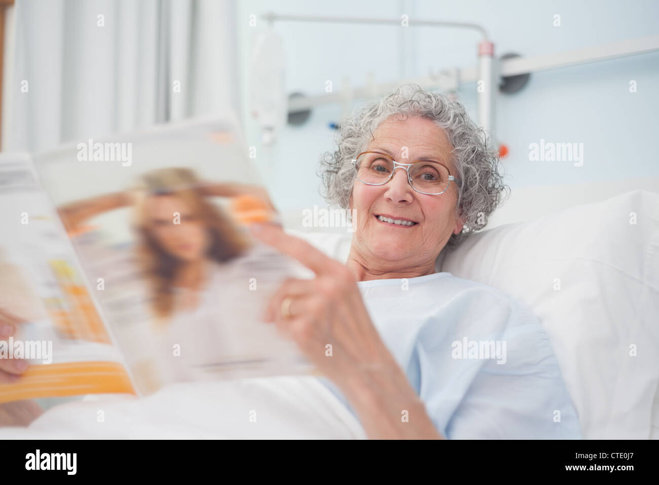 Elderly patient reading a magazine Stock Photo - Alamy