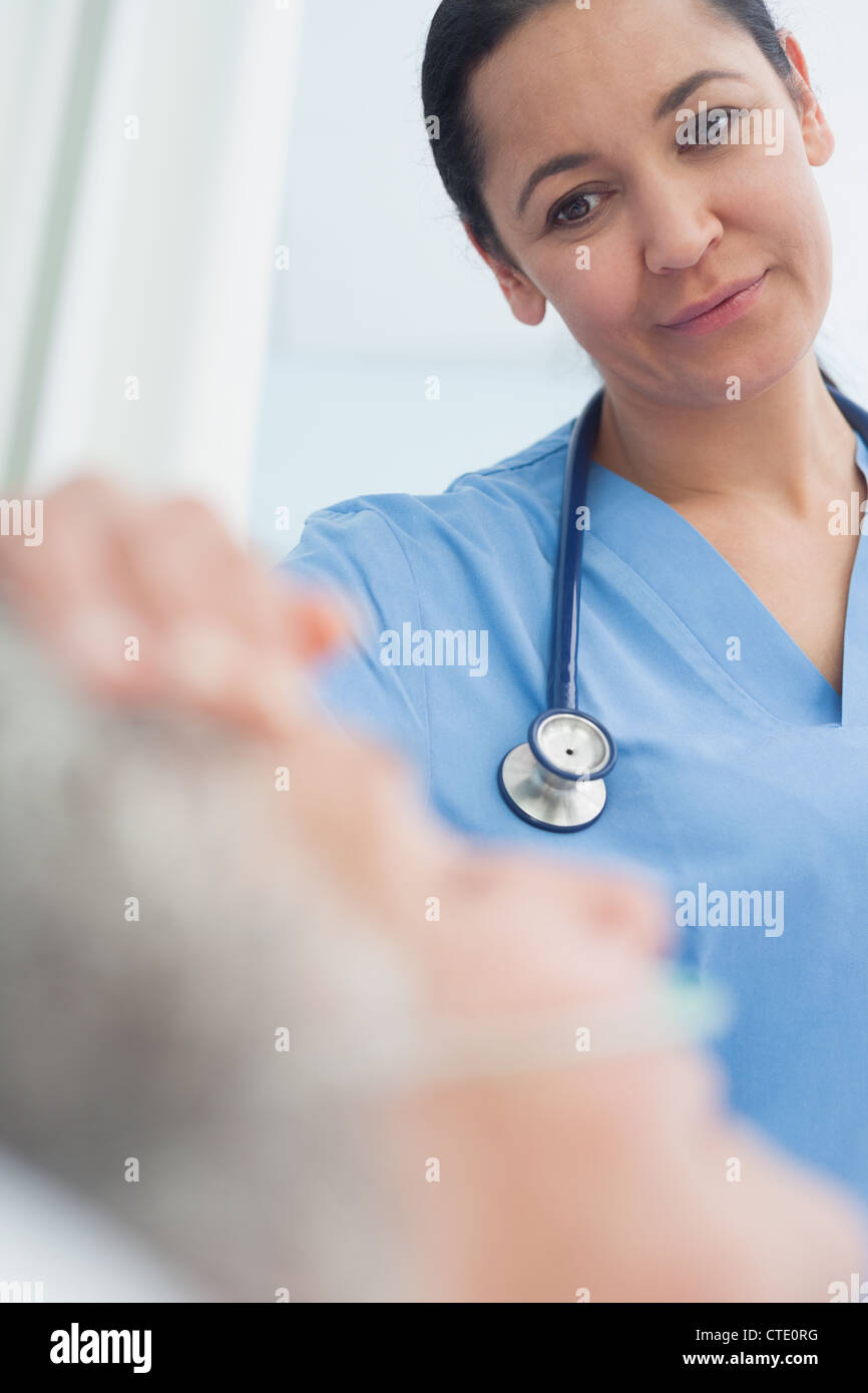 Smiling nurse looking at a patient Stock Photo - Alamy