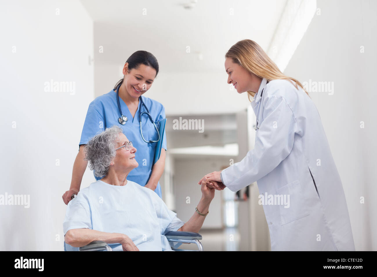 Patient in a wheelchair holding hand of a doctor Stock Photo - Alamy