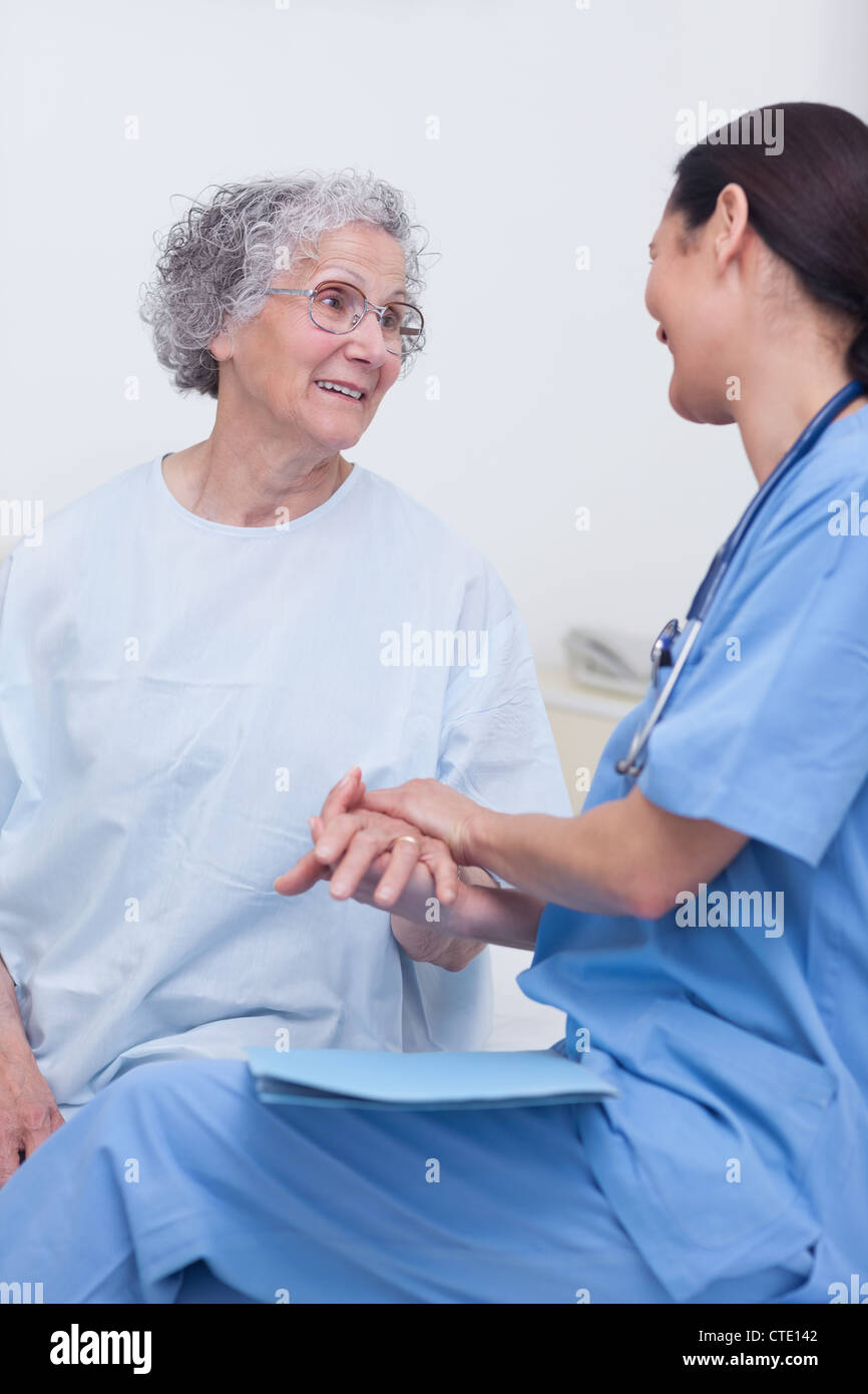 Nurse and a patient sitting on a bed Stock Photo - Alamy