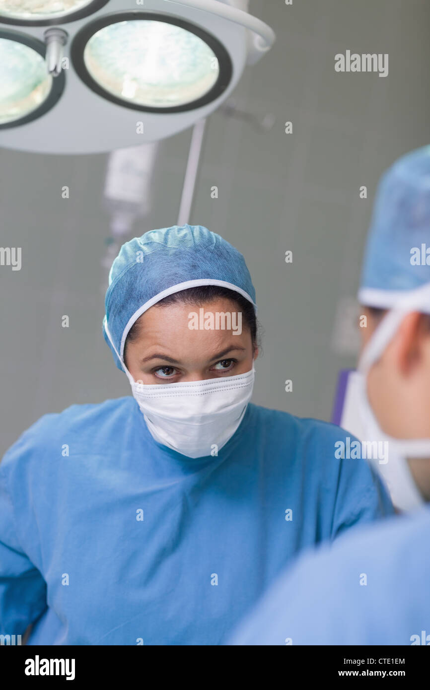 Serious nurse looking at a doctor Stock Photo - Alamy
