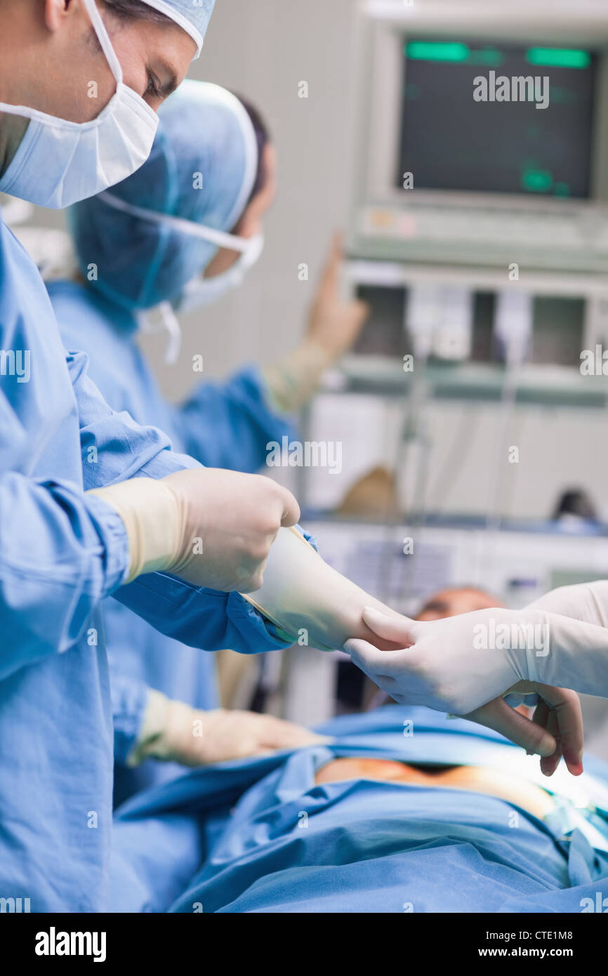 Doctor removing his gloves Stock Photo - Alamy