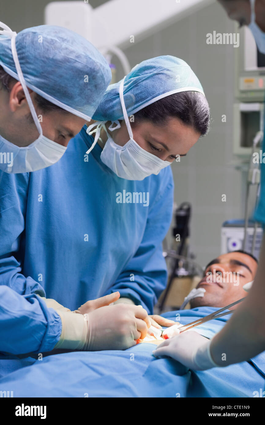 Serious doctors looking at a patient Stock Photo - Alamy