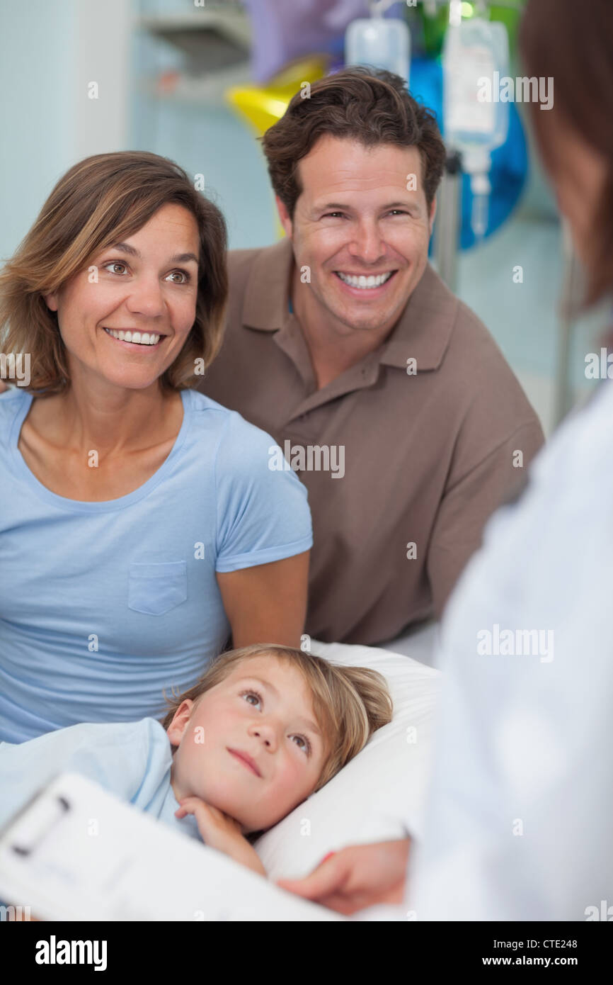Parents and child looking at a doctor Stock Photo - Alamy