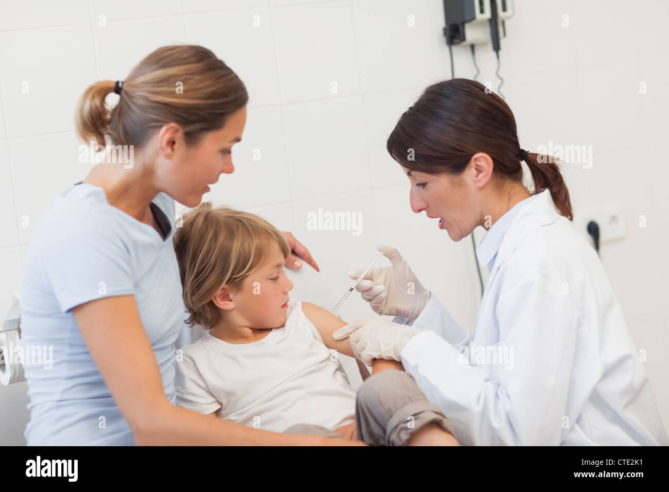 Child receiving an injection by a doctor Stock Photo - Alamy