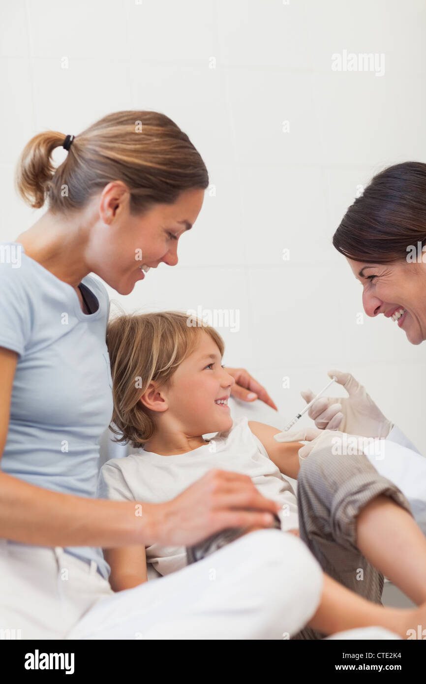 Child sitting on a bed receiving an injection Stock Photo - Alamy