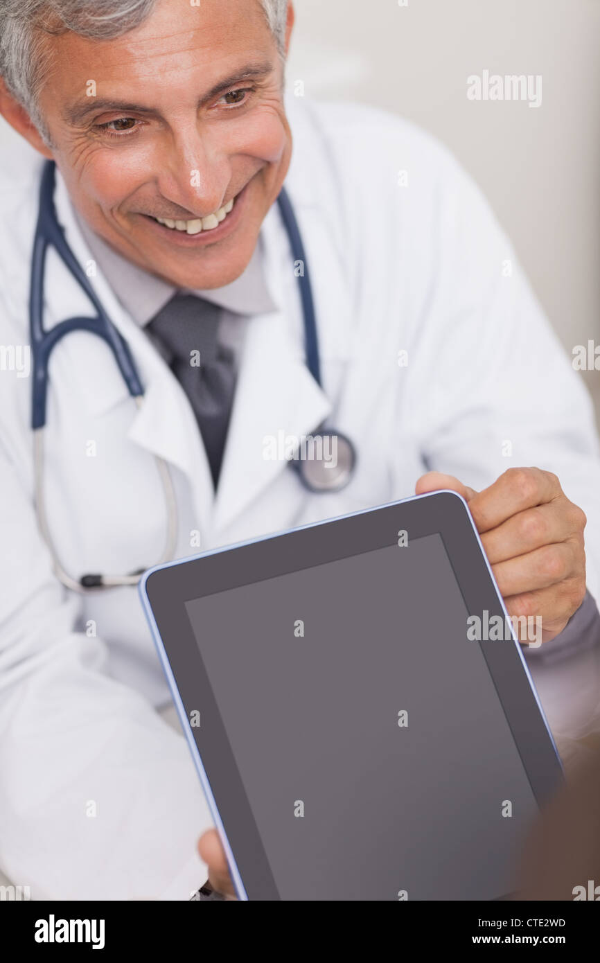 Doctor holding a tablet computer while smiling Stock Photo - Alamy