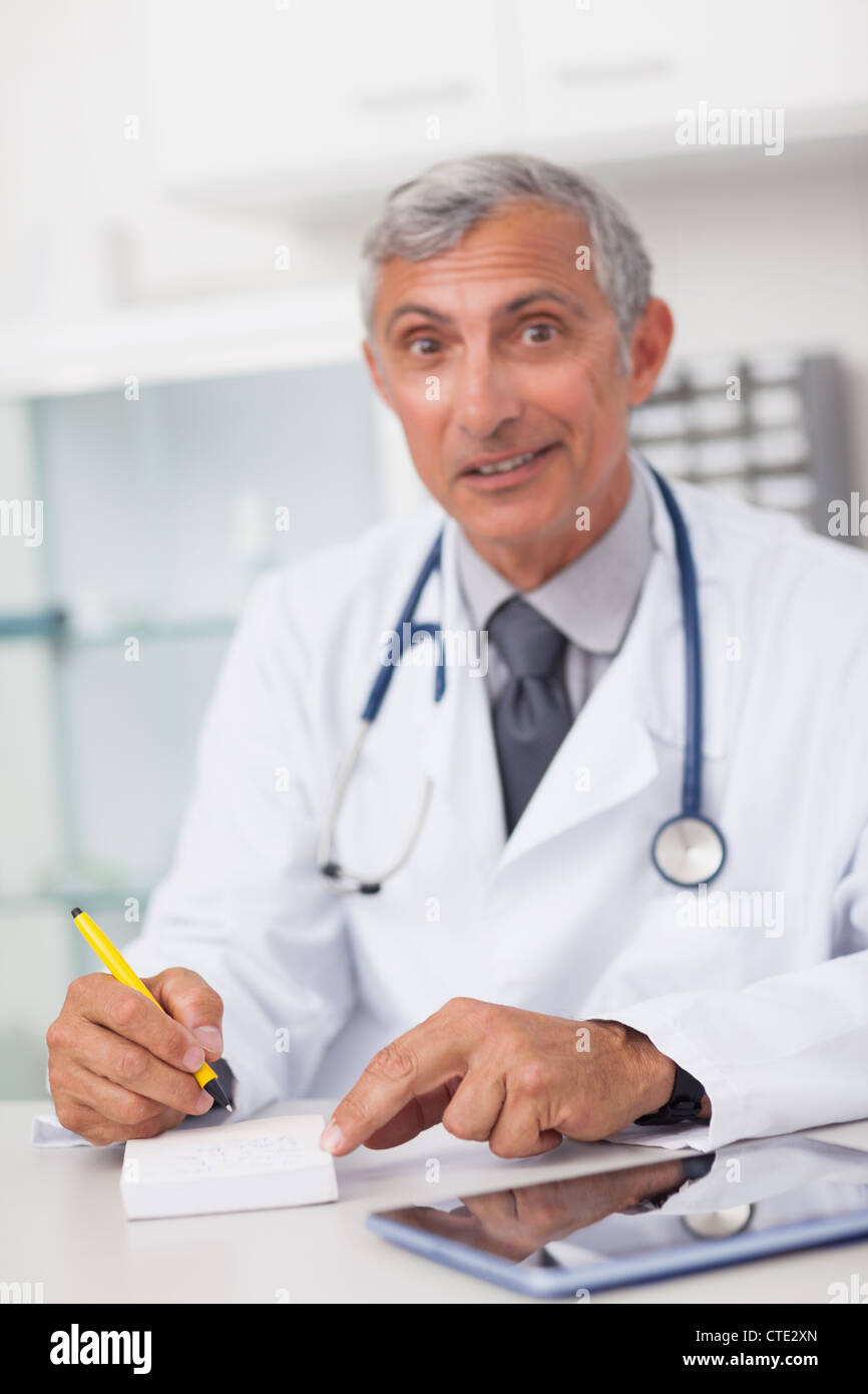 Doctor looking at camera while holding a pen Stock Photo - Alamy