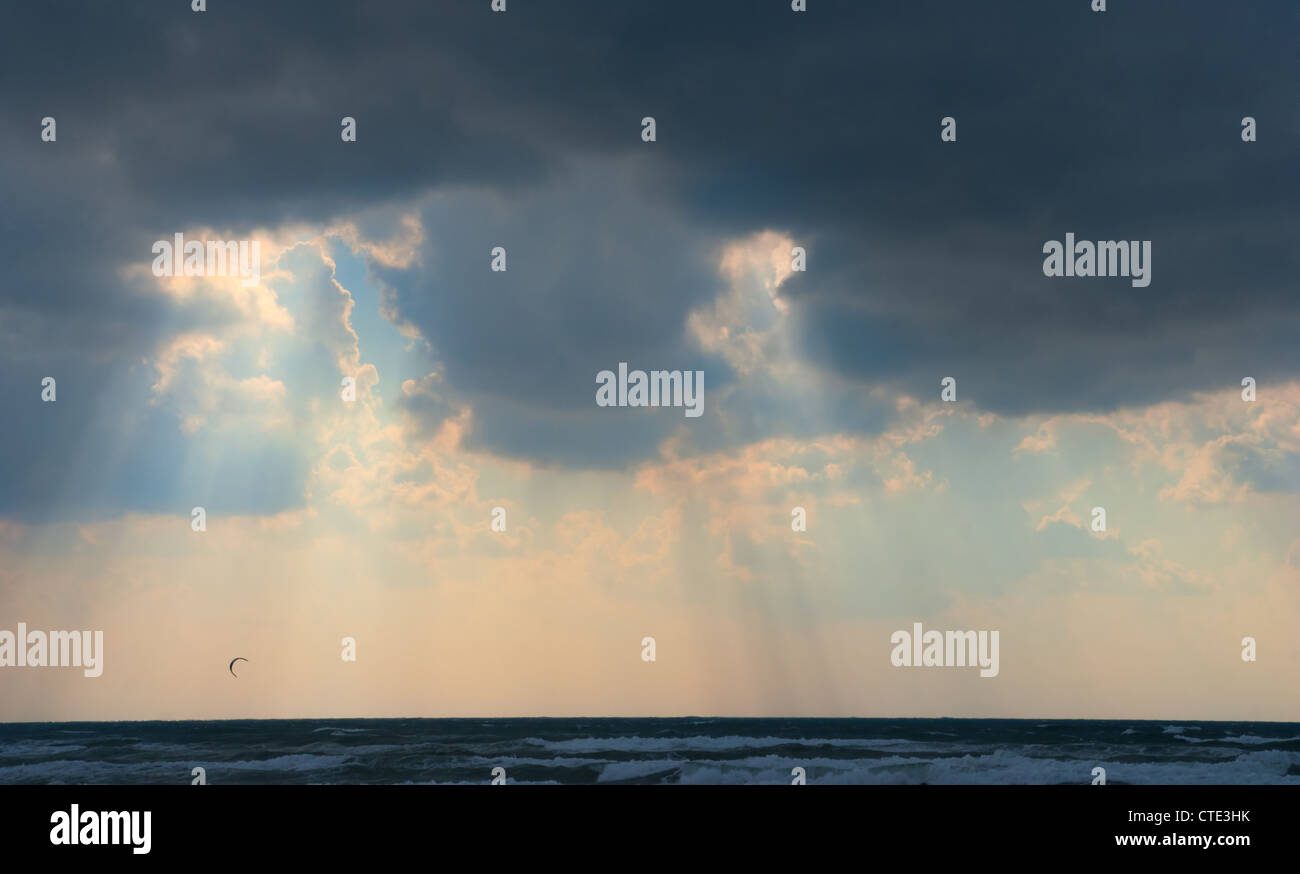 Sun behind dark storm clouds over the sea Stock Photo - Alamy