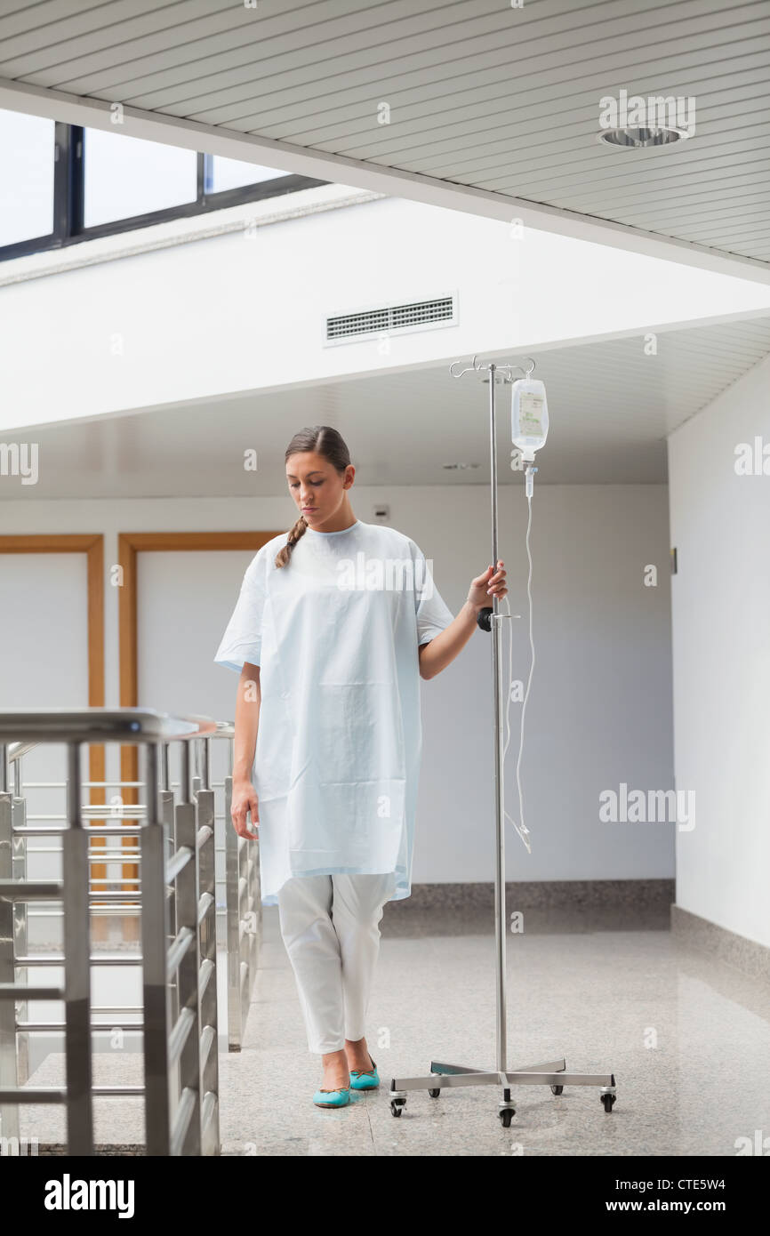 Female patient walking while holding a drip stand Stock Photo - Alamy