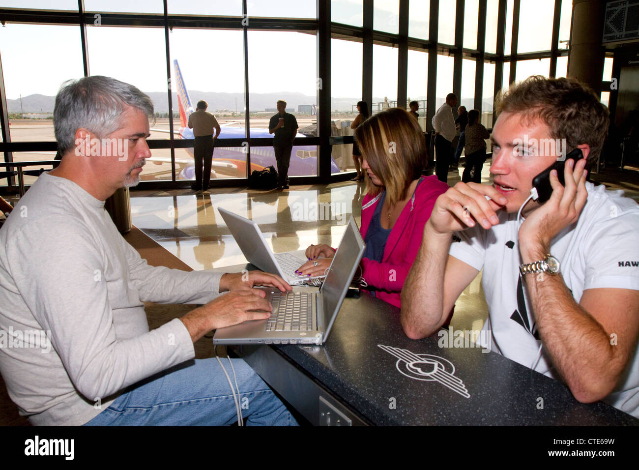 People use wi-fi internet at the Phoenix Sky Harbor International ...