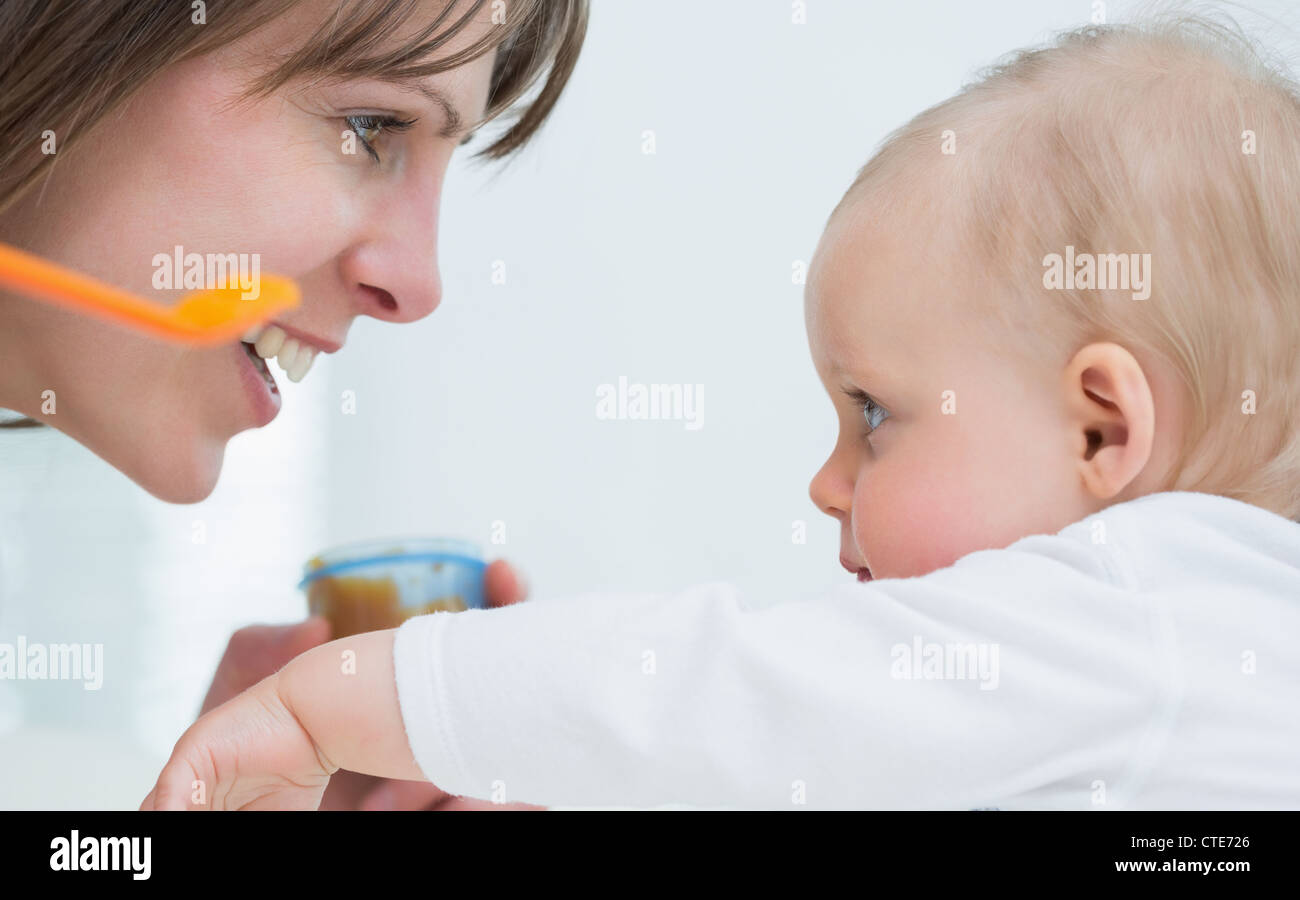 Mother face in front of a baby Stock Photo - Alamy