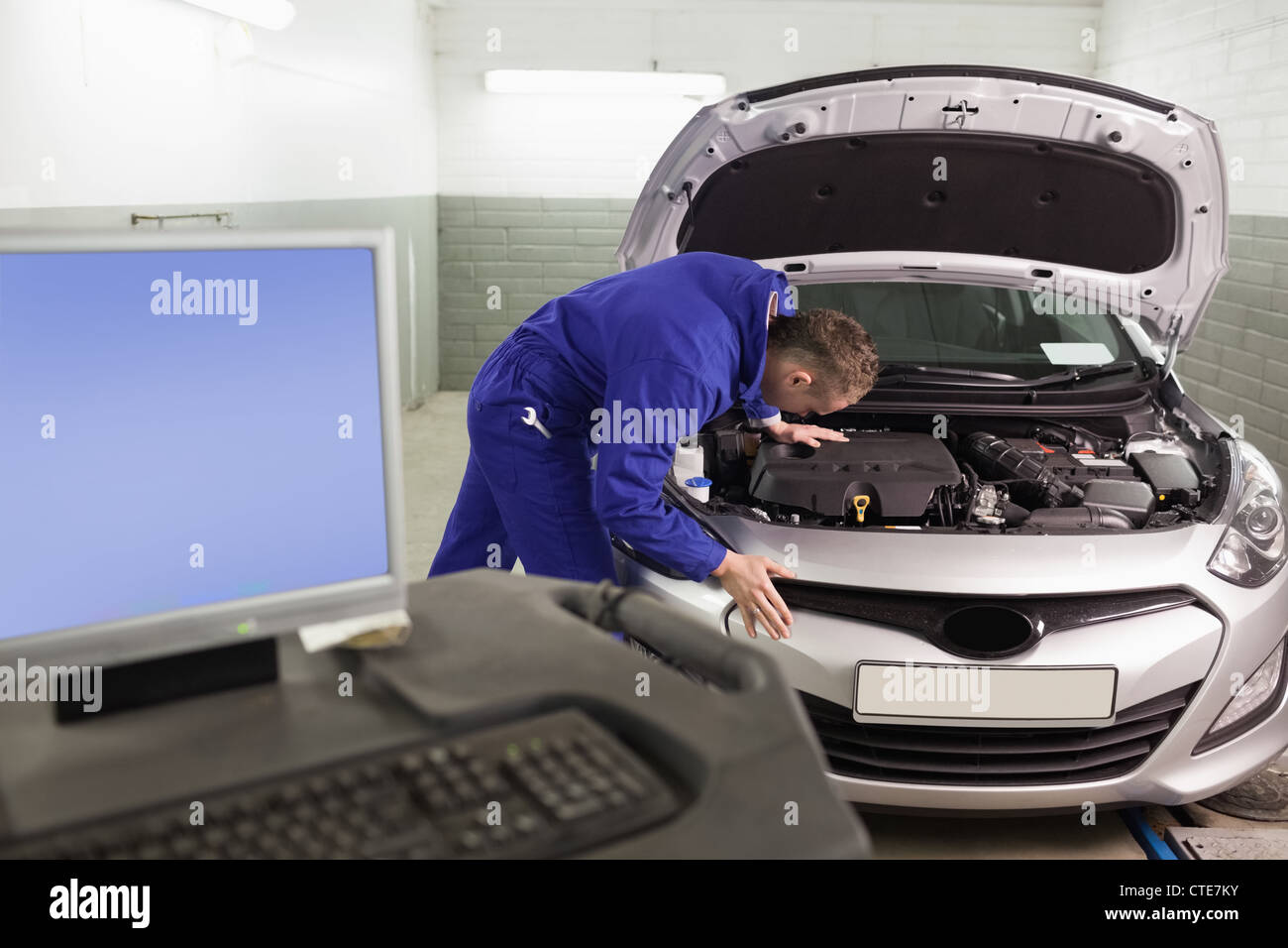 Mechanic repairing a car next to a computer Stock Photo - Alamy