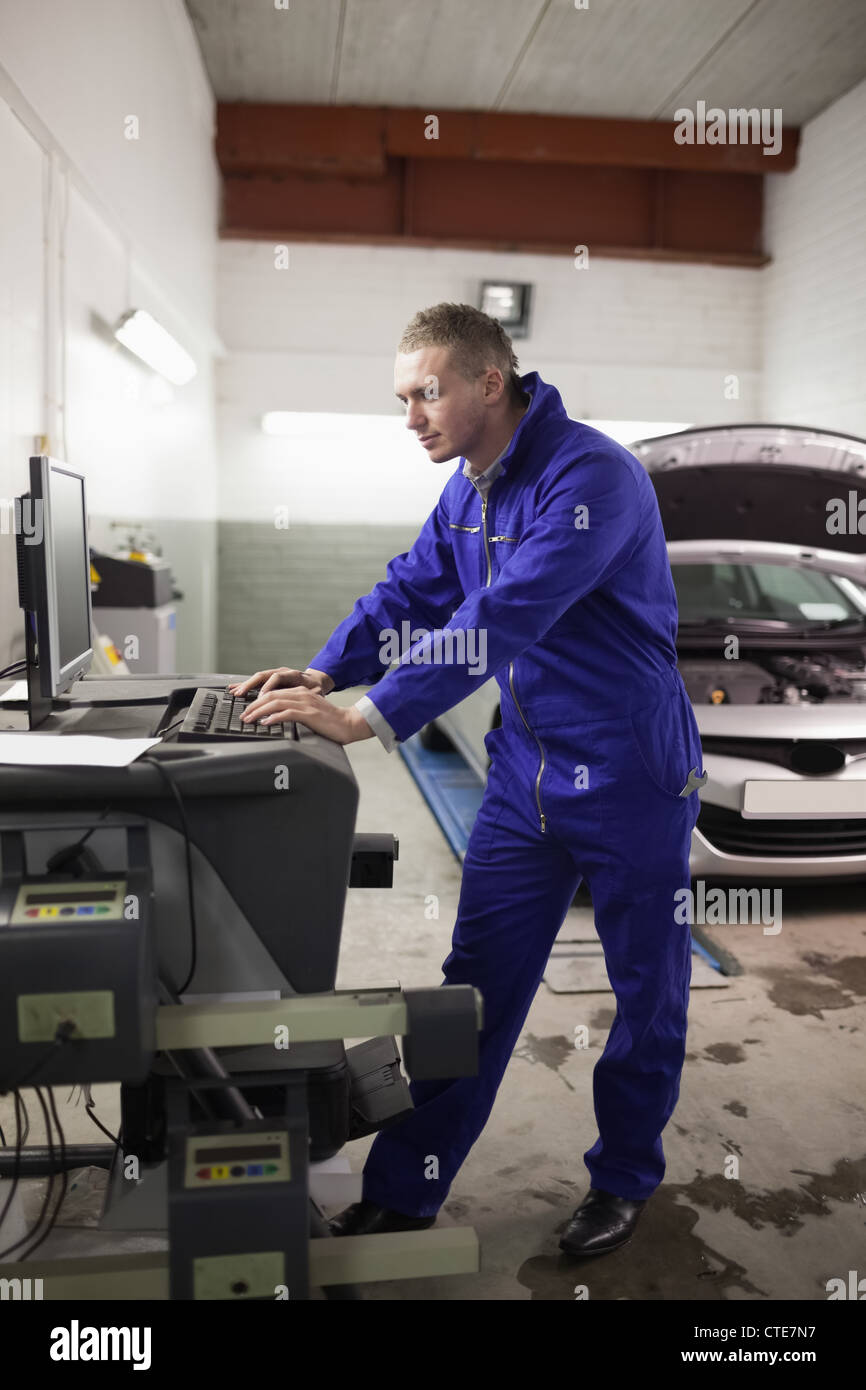 Concentrated mechanic using a computer Stock Photo - Alamy