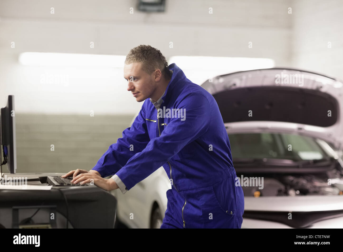 Mechanic looking at a computer Stock Photo - Alamy
