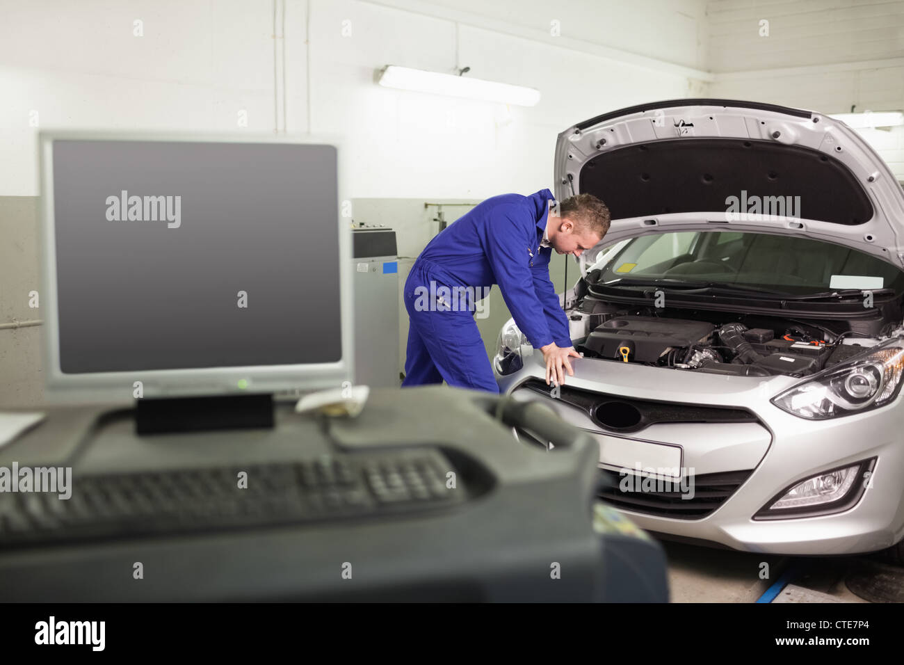 Mechanic examining a car engine Stock Photo - Alamy