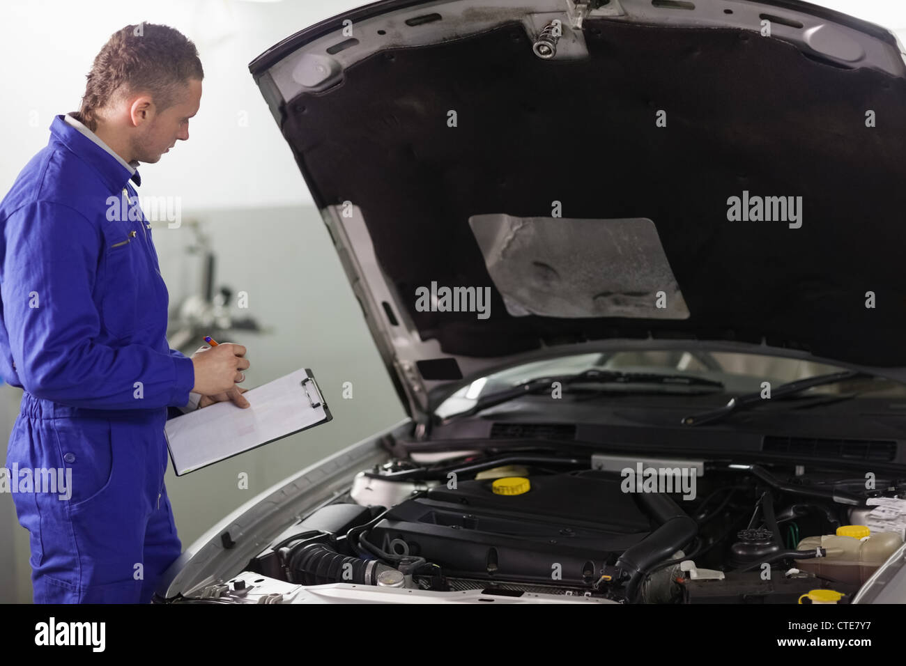 Mechanic holding a notepad Stock Photo - Alamy