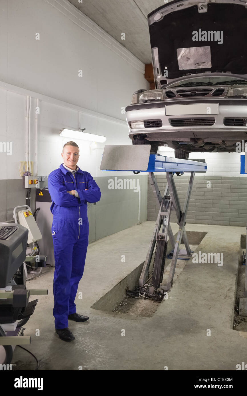 Mechanic standing next to a car Stock Photo - Alamy