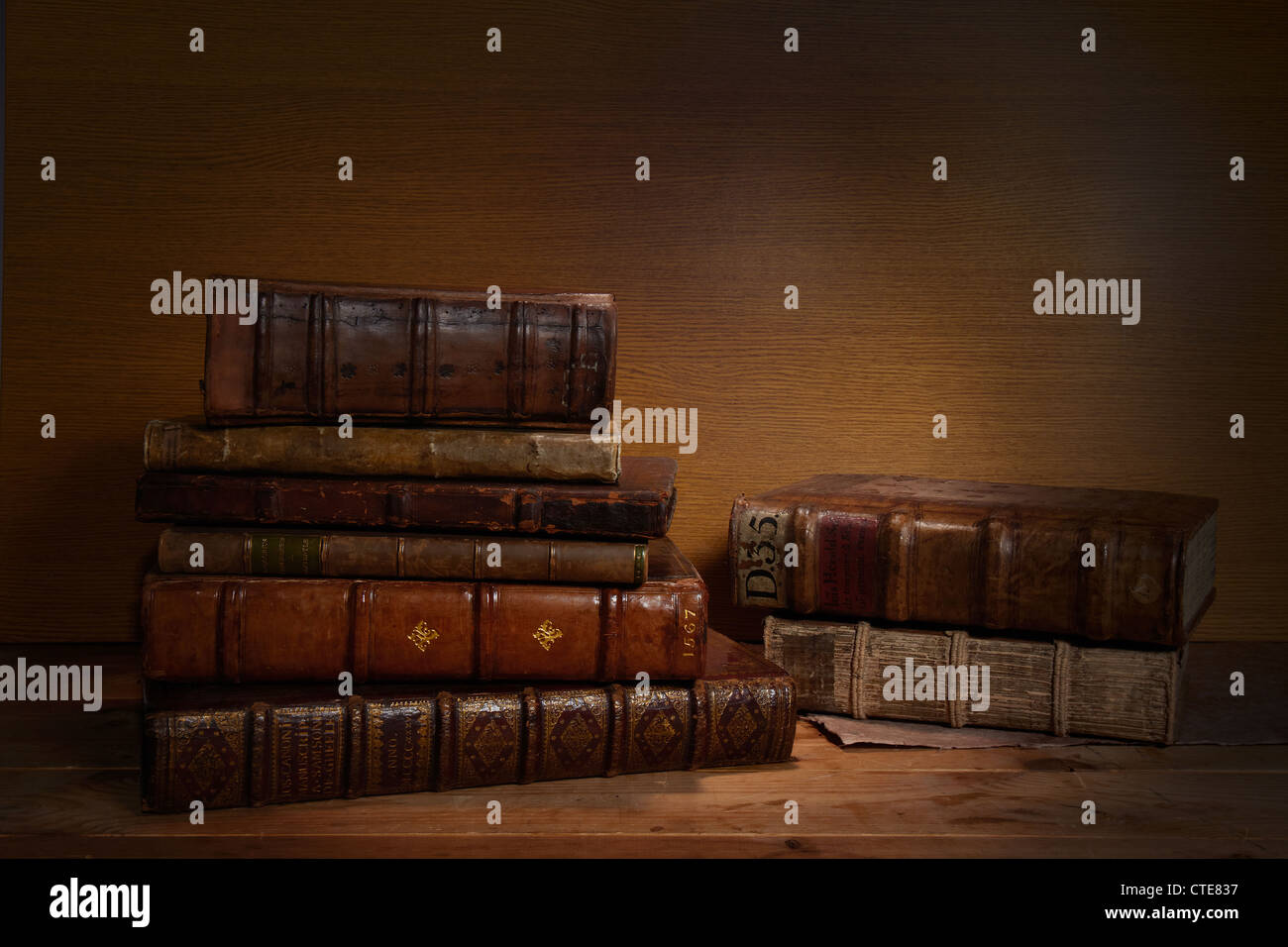 a selection of very old books against wood with dark lighting Stock ...