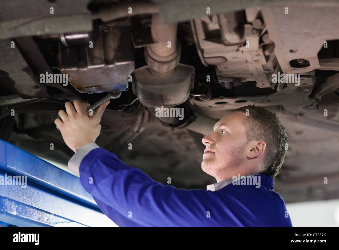 Mechanic repairing the below of a car Stock Photo - Alamy