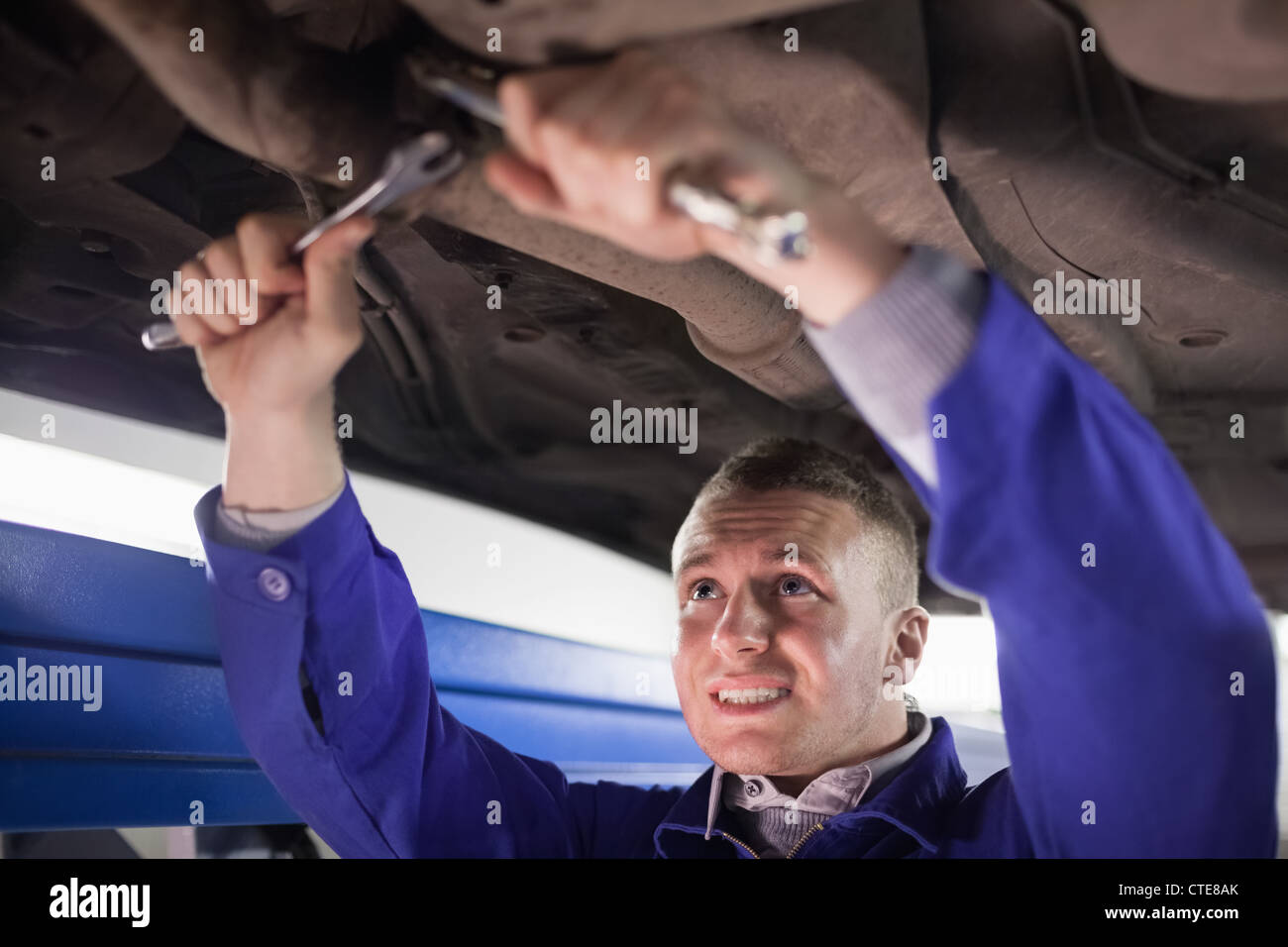 Mechanic repairing a car while using tools Stock Photo - Alamy