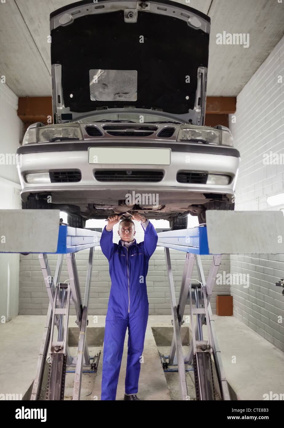 Mechanic standing while repairing a car Stock Photo - Alamy