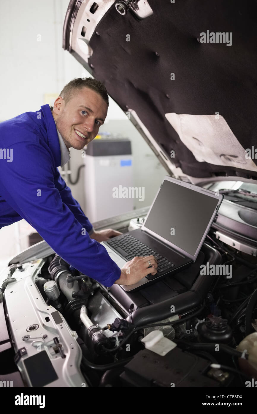 Smiling mechanic working on a computer Stock Photo - Alamy