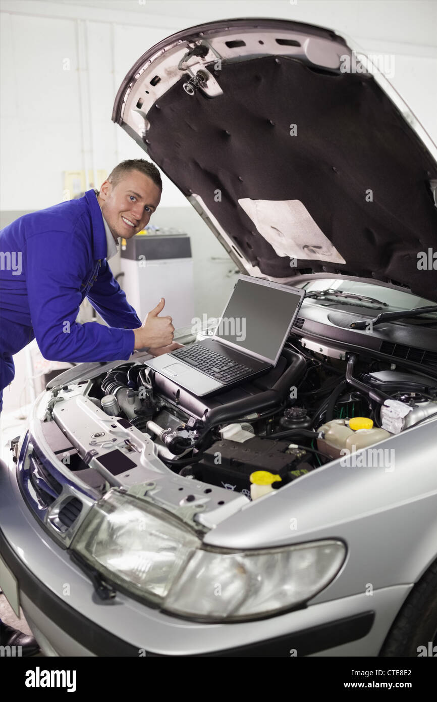 Mechanic repairing a car with a computer Stock Photo - Alamy