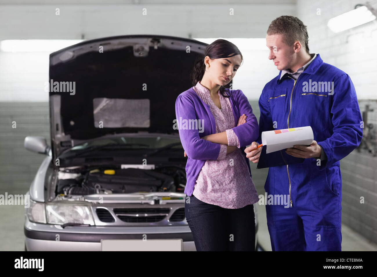 Mechanic showing the quotation to a client Stock Photo - Alamy