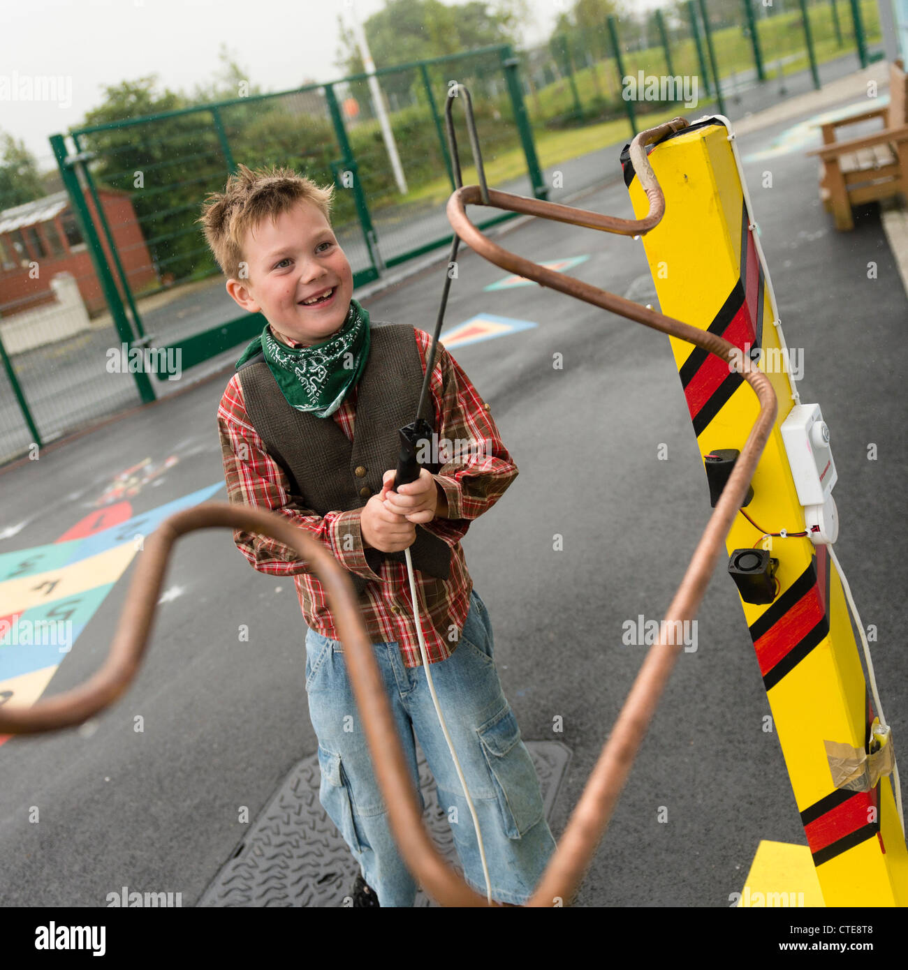 A boy testing his skill and eye-hand co-ordination on buzz wire maze ...
