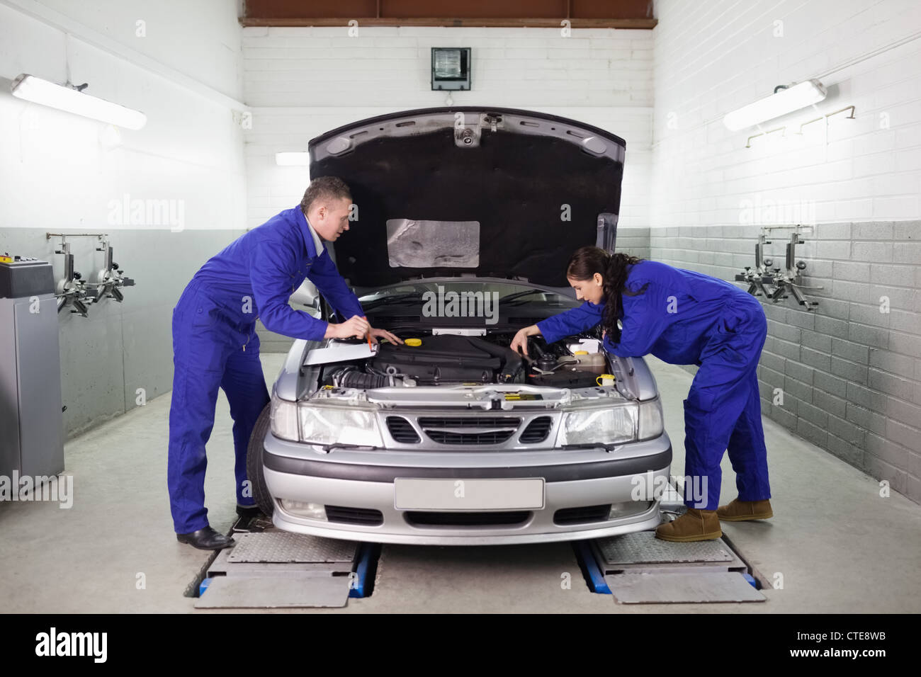 Mechanics looking at the engine Stock Photo - Alamy