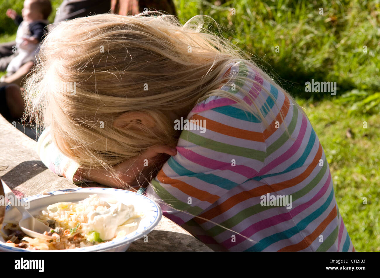 Little girl not eating and sitting with her head down Stock Photo - Alamy