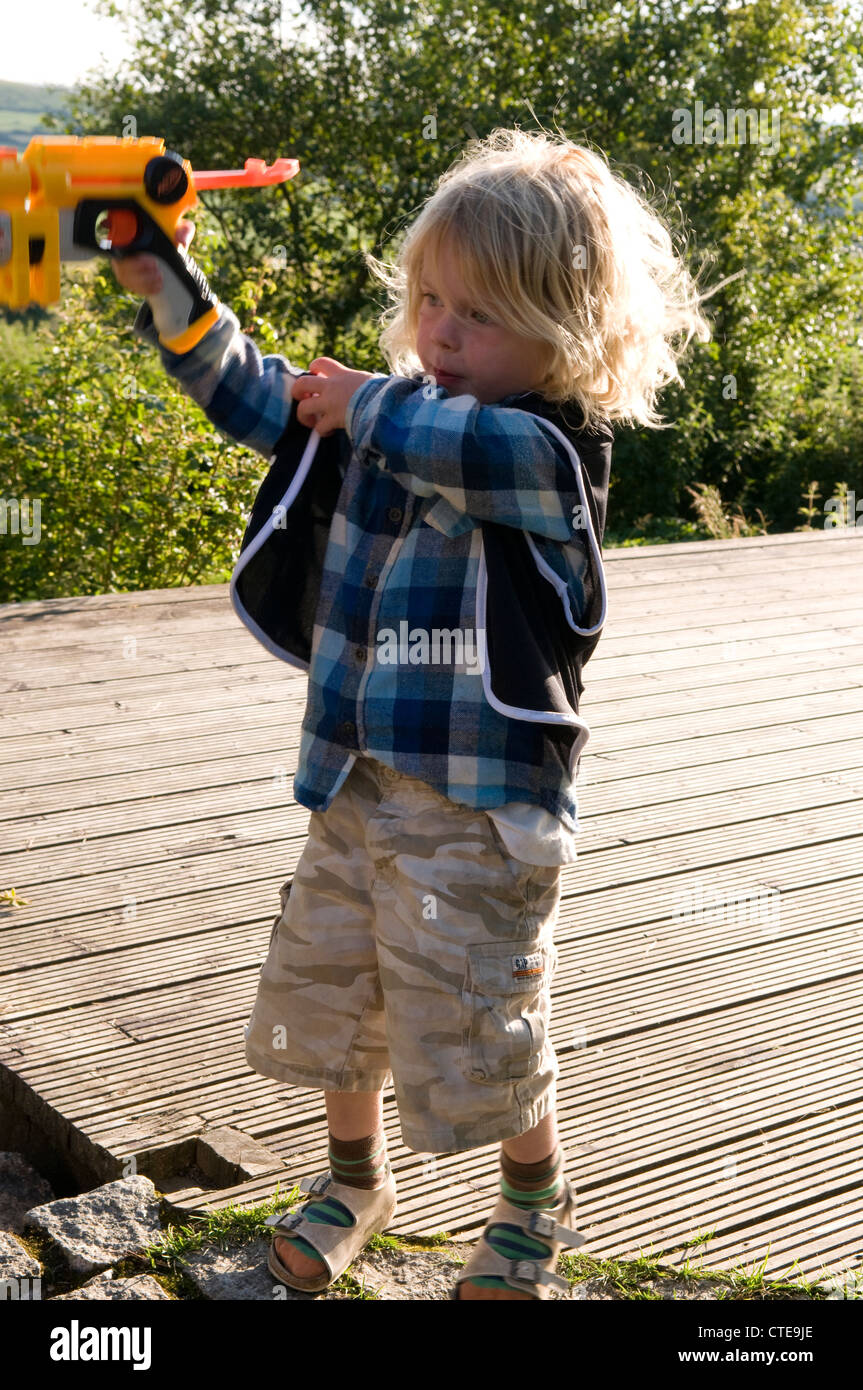 Little boy playing with a toy gun outside Stock Photo - Alamy