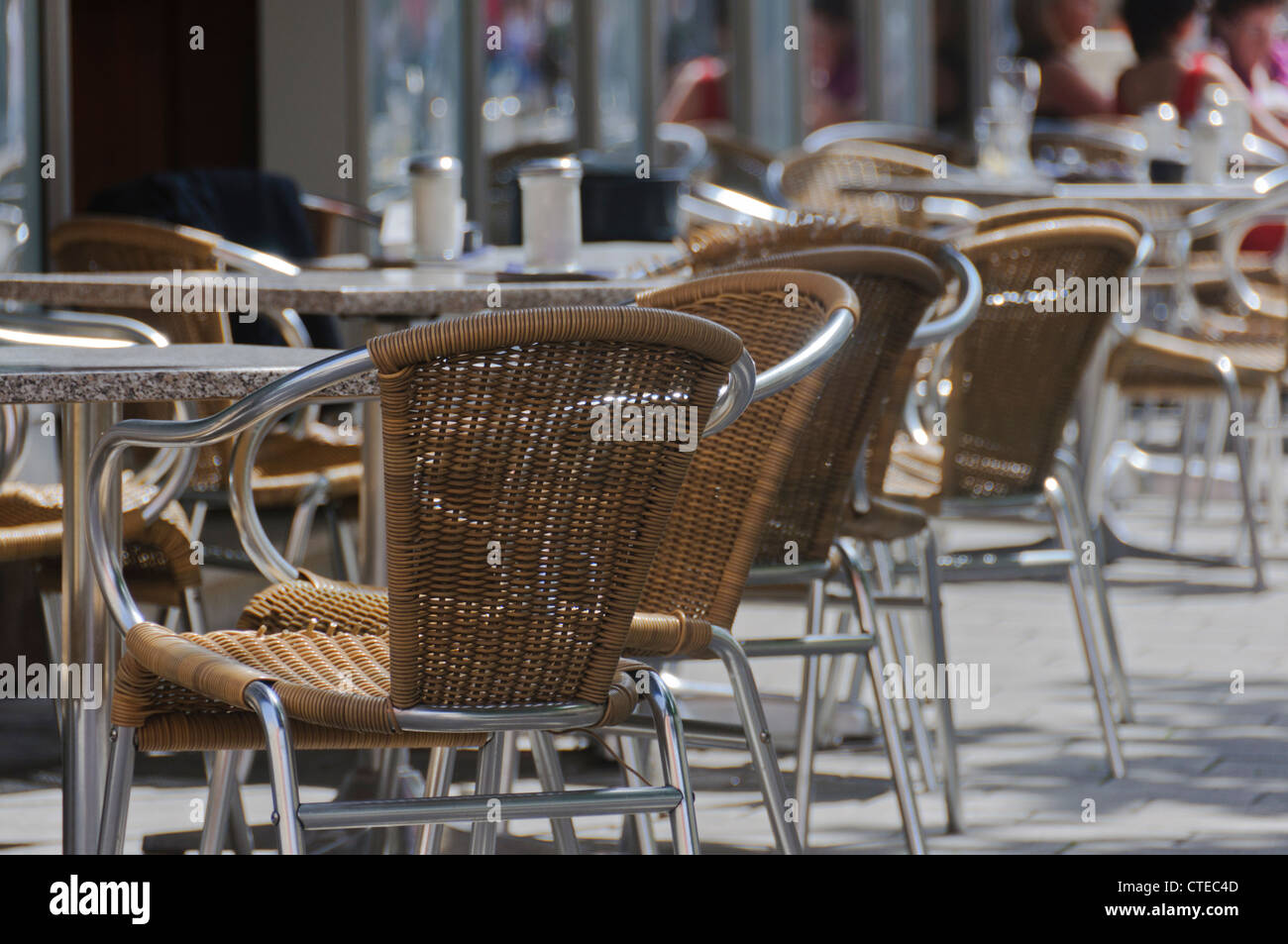 Brown beige wicker chairs in pavement sidewalk café bistrot tables ...
