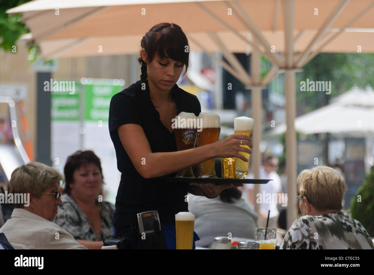 Waitress with ponytail serves German Wheat Beer in Pavement Sidewalk ...