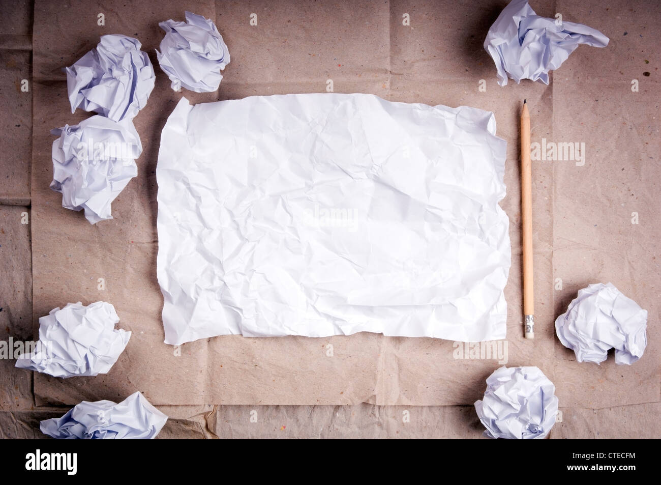 Writing concept - crumpled up paper wads with a sheet of white paper ...