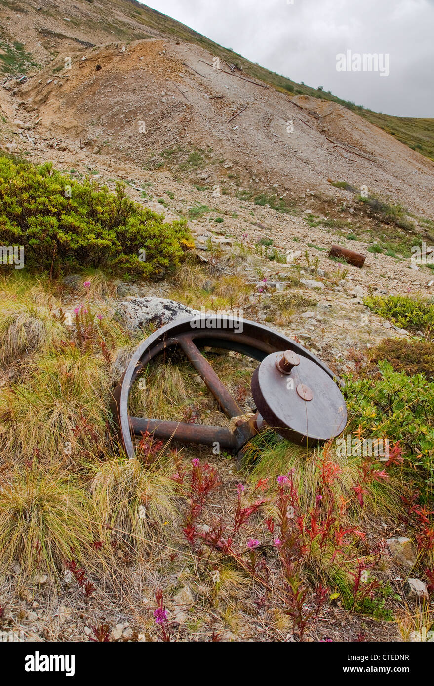 A large gear wheel lies abandoned near mining tailings in Yukon ...