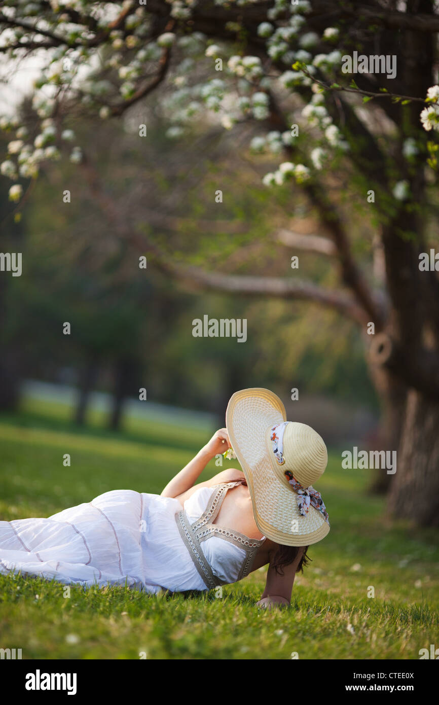 Beautiful woman sitting on the grass in summer park Stock Photo - Alamy