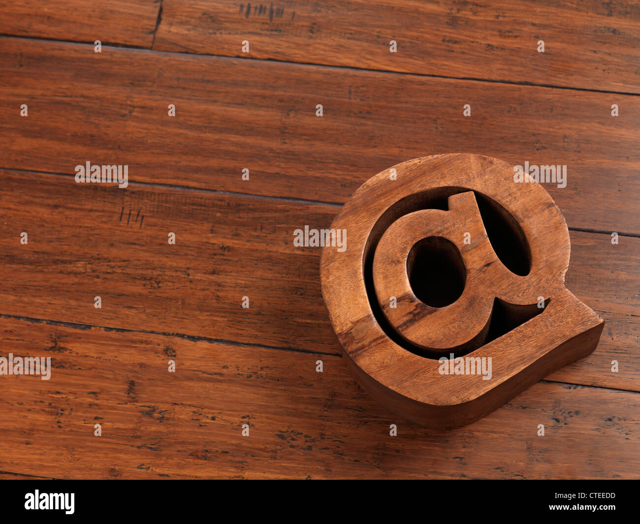 Email address symbol AT @ made of wood lying on hardwwod floor ...