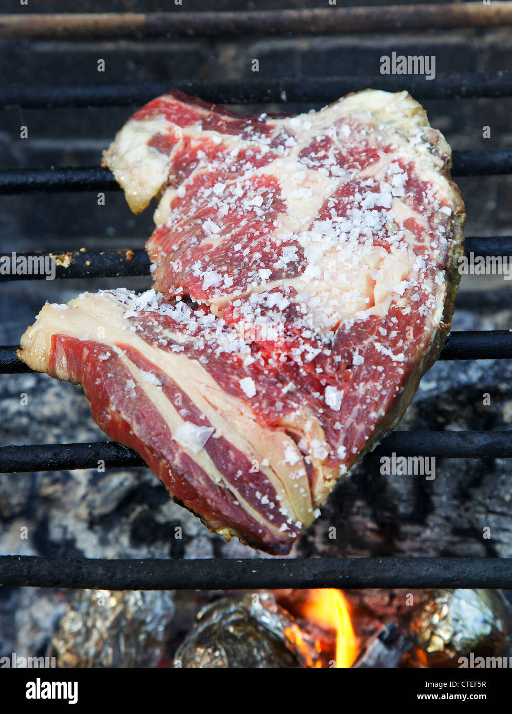Coocking a Cow chop at grill Stock Photo - Alamy