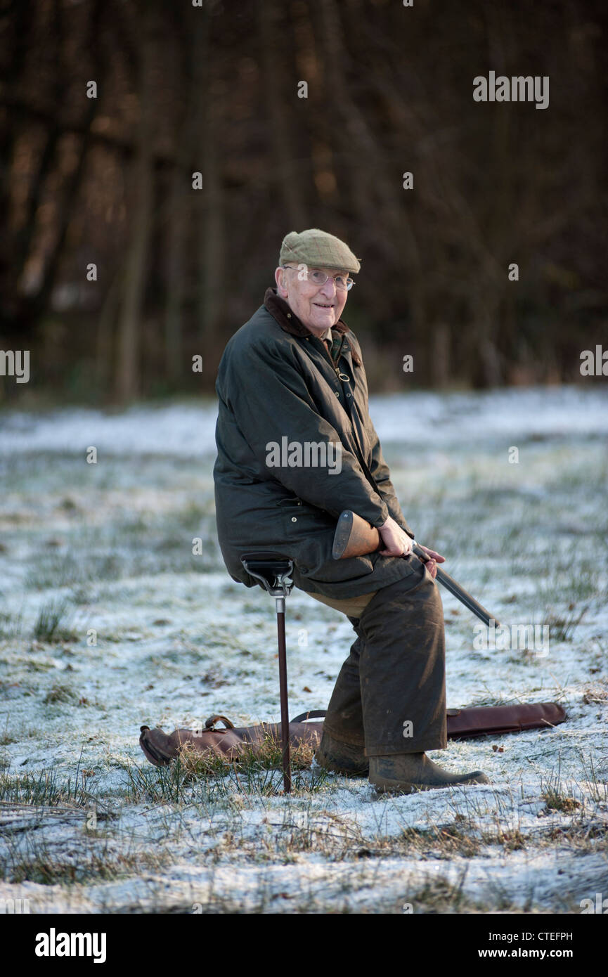 older man sitting on shooting peg Stock Photo - Alamy