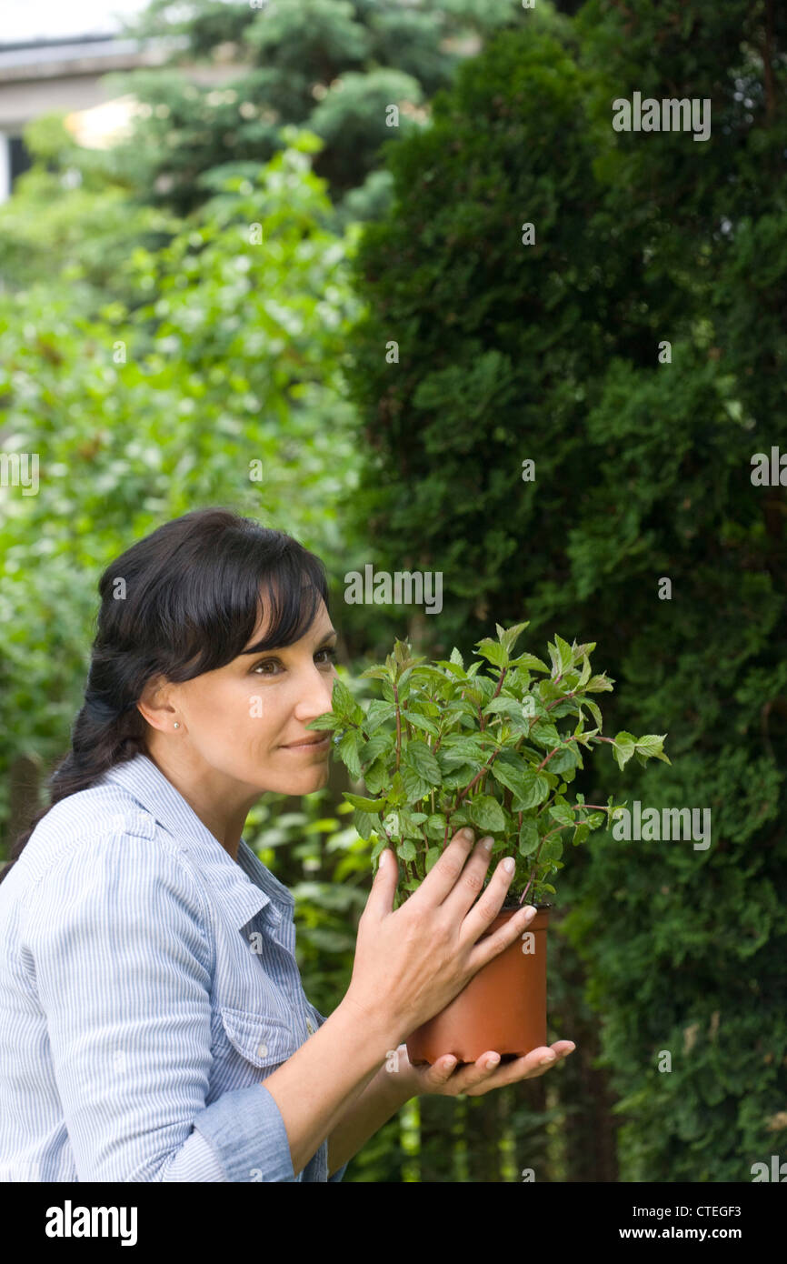 Woman smelling fresh mint Stock Photo - Alamy