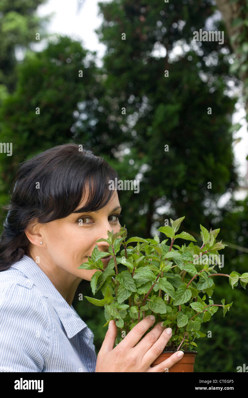 Woman smelling fresh mint Stock Photo - Alamy