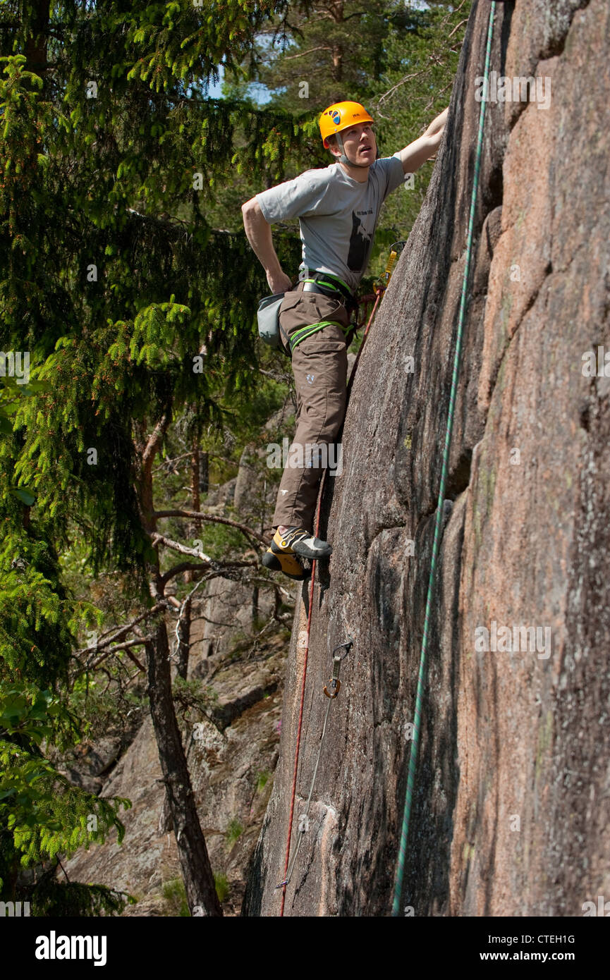 Climber climbing a rock wall Stock Photo - Alamy