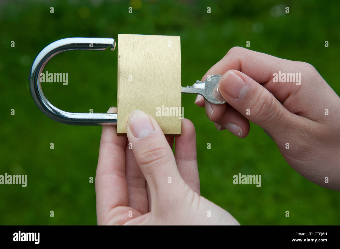 Padlock and key held in a young woman's hands Stock Photo - Alamy