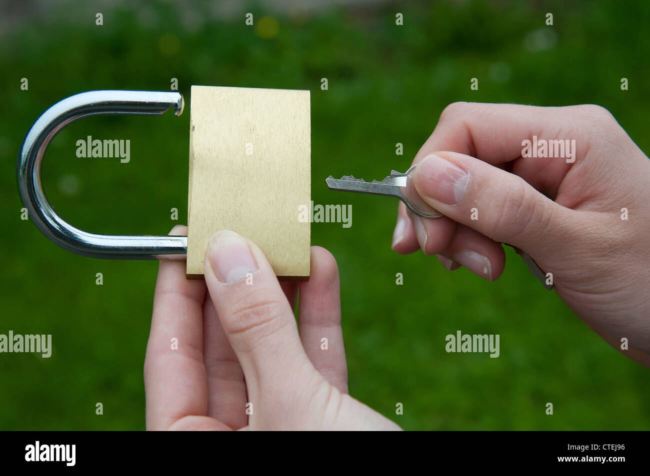 Padlock and key held in a young woman's hands Stock Photo - Alamy